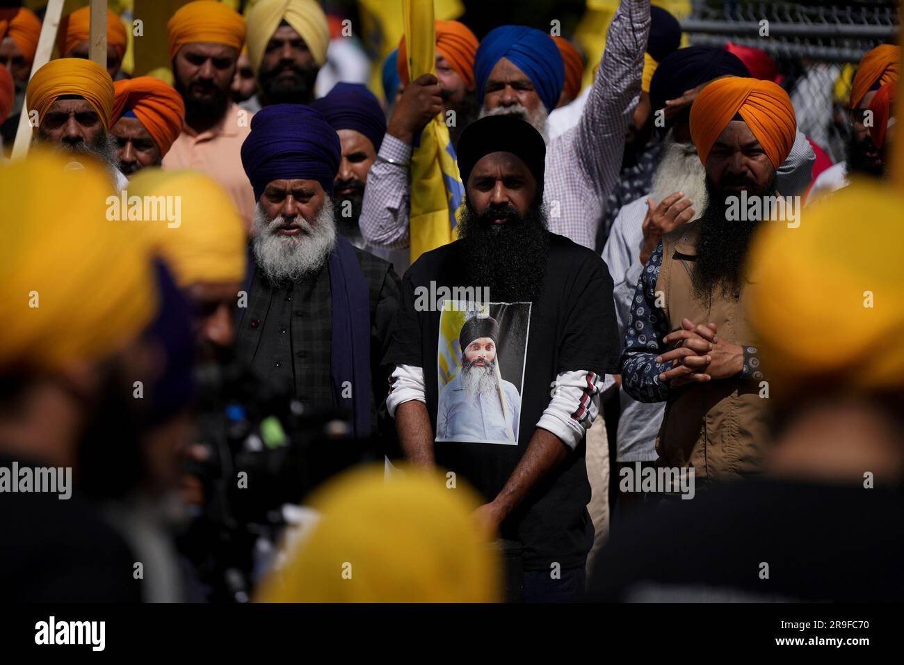 A mourner wears a t-shirt bearing a photograph of Sikh community leader and temple president ...