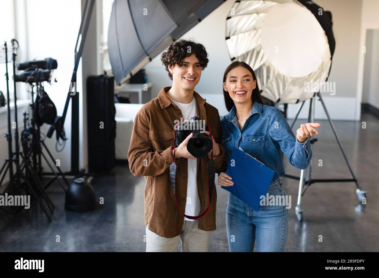 Happy man photographer and female art director discussing models and ...