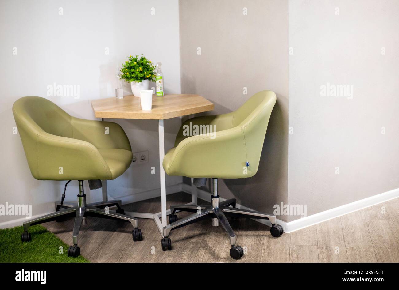 table with a green office chair in the corner of a brick wall in an ...