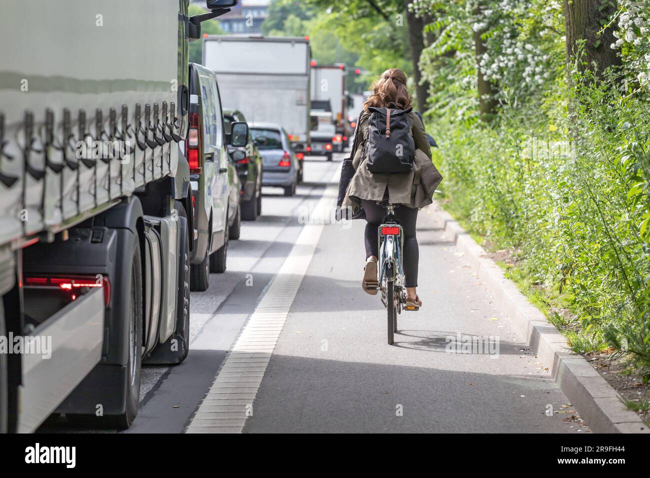 Cyclist on painted bike lane next to truck Stock Photo - Alamy