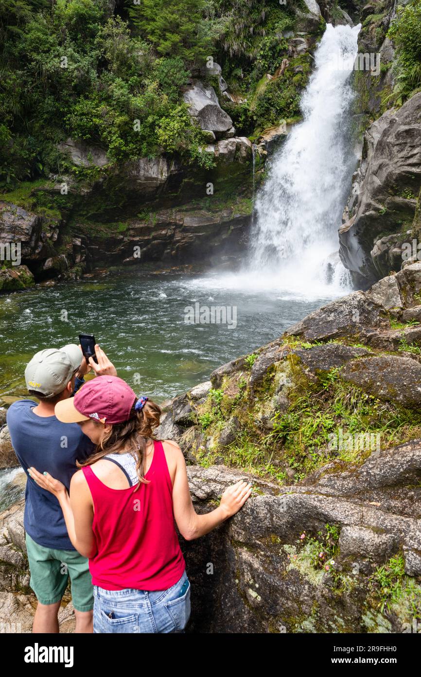 A couple pose at Wainui Falls Waterfalls Wainui Bay, Tasman Region, New ...