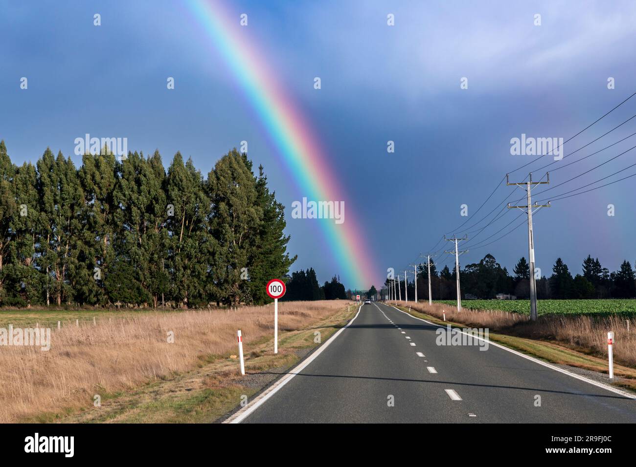 Photograph of a large rainbow over a regional road and agricultural ...