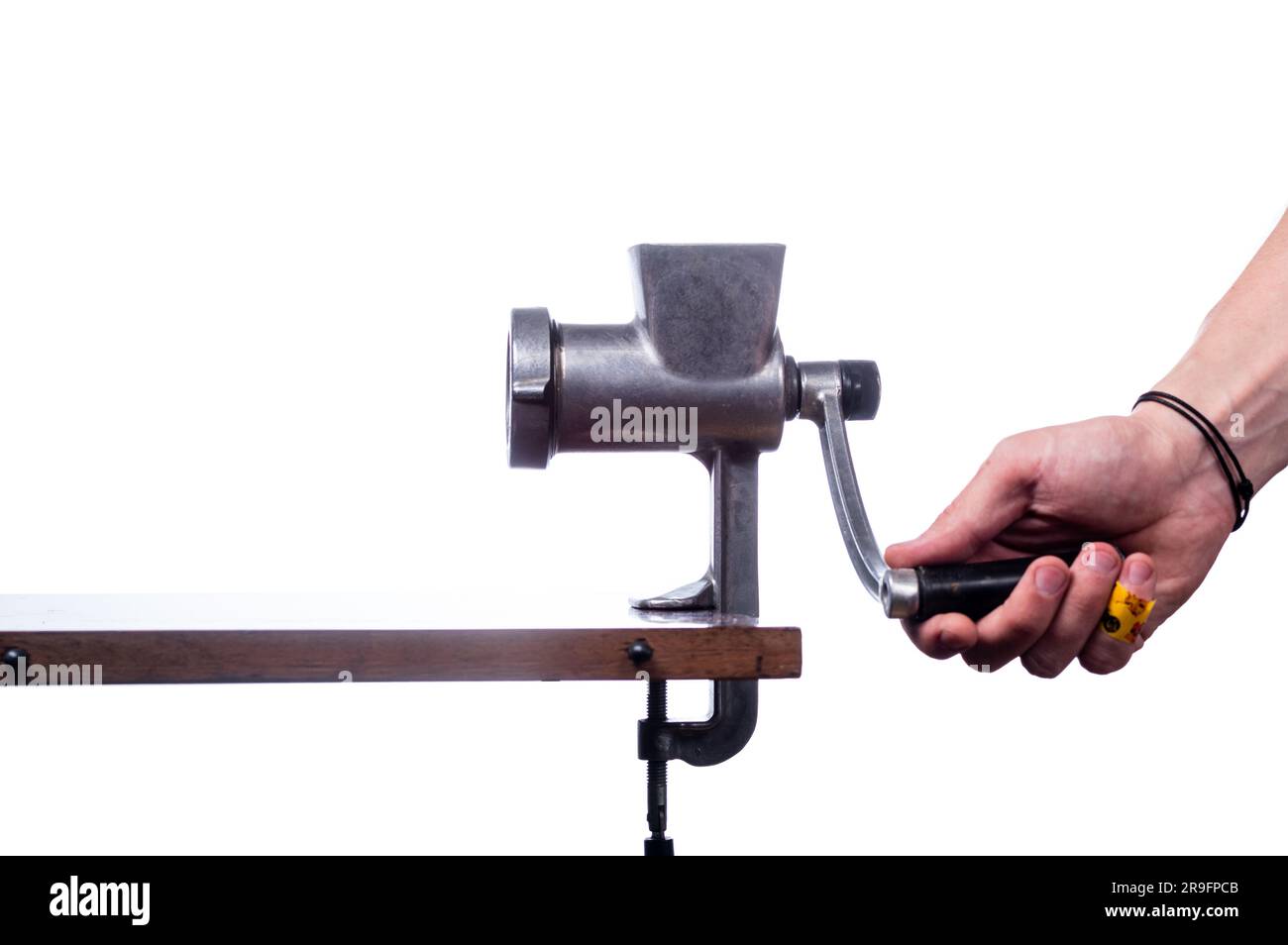 The hand holds an empty meat grinder. The hand twists the meat grinder ...