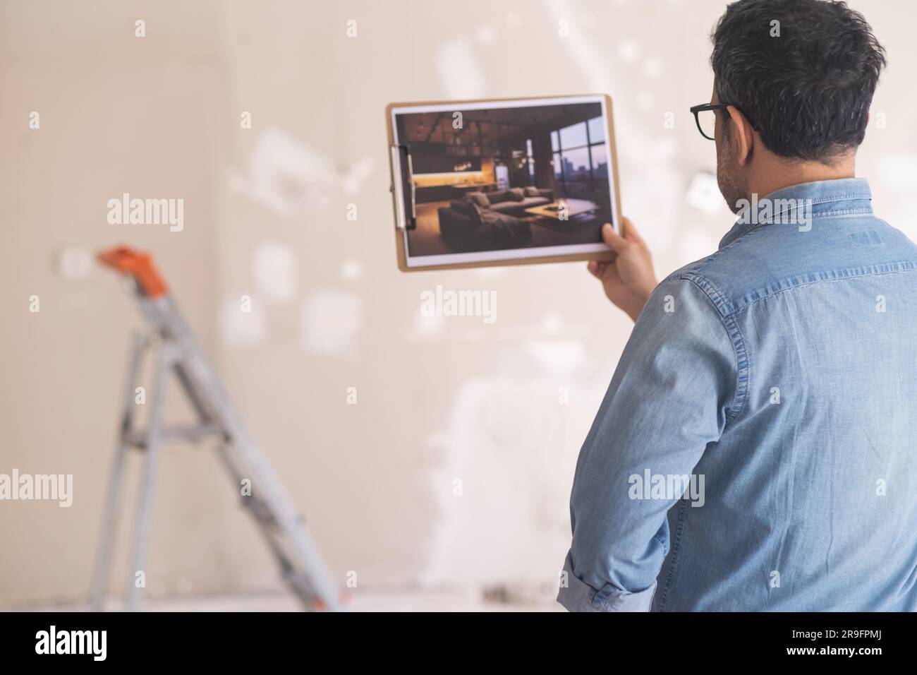 Man in glasses looking at picture with loft-style interior design ...