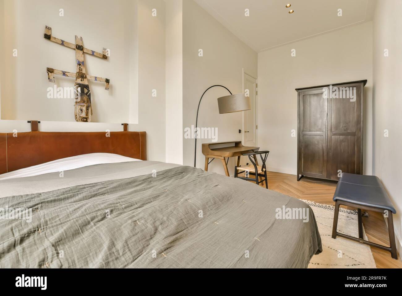 a bedroom with a bed, desk and chair in front of the door that leads to ...