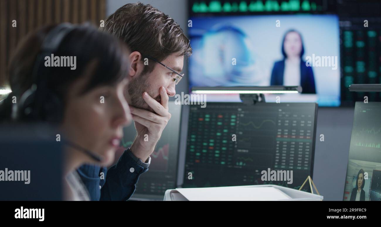Financial analysts work on multi-monitor computer with real-time stocks and exchange market ...