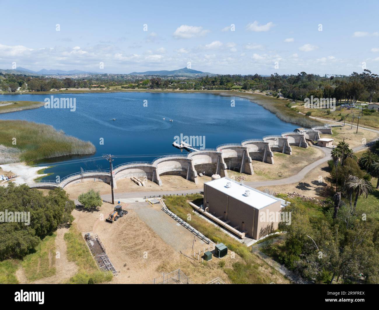 Aerial view over water reservoir and a large dam that holds water ...
