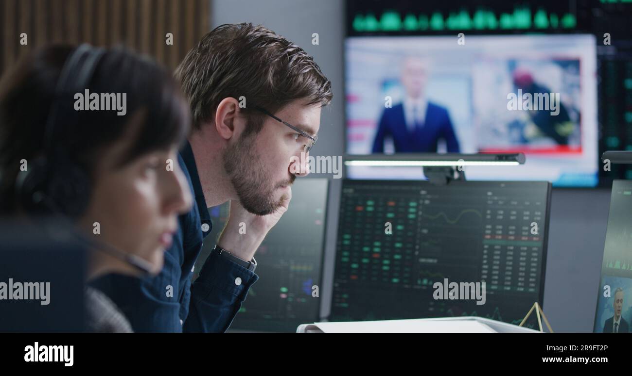 Financial analysts work on multi-monitor computer with real-time stocks and exchange market ...