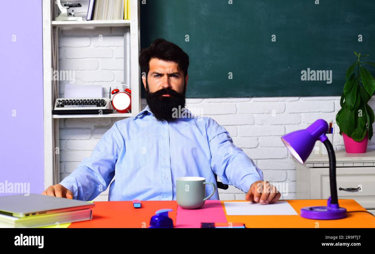 Serious bearded male teacher in classroom. Learning and education ...