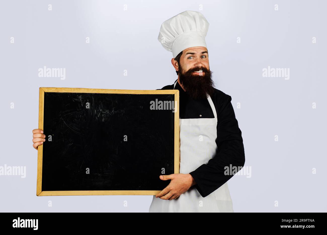 Advertising chef menu. Smiling restaurant chef in uniform holds empty ...