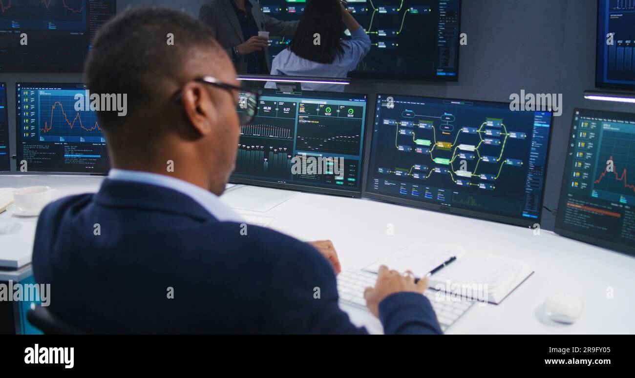 Software programmer sits in front of computer with blockchain network ...