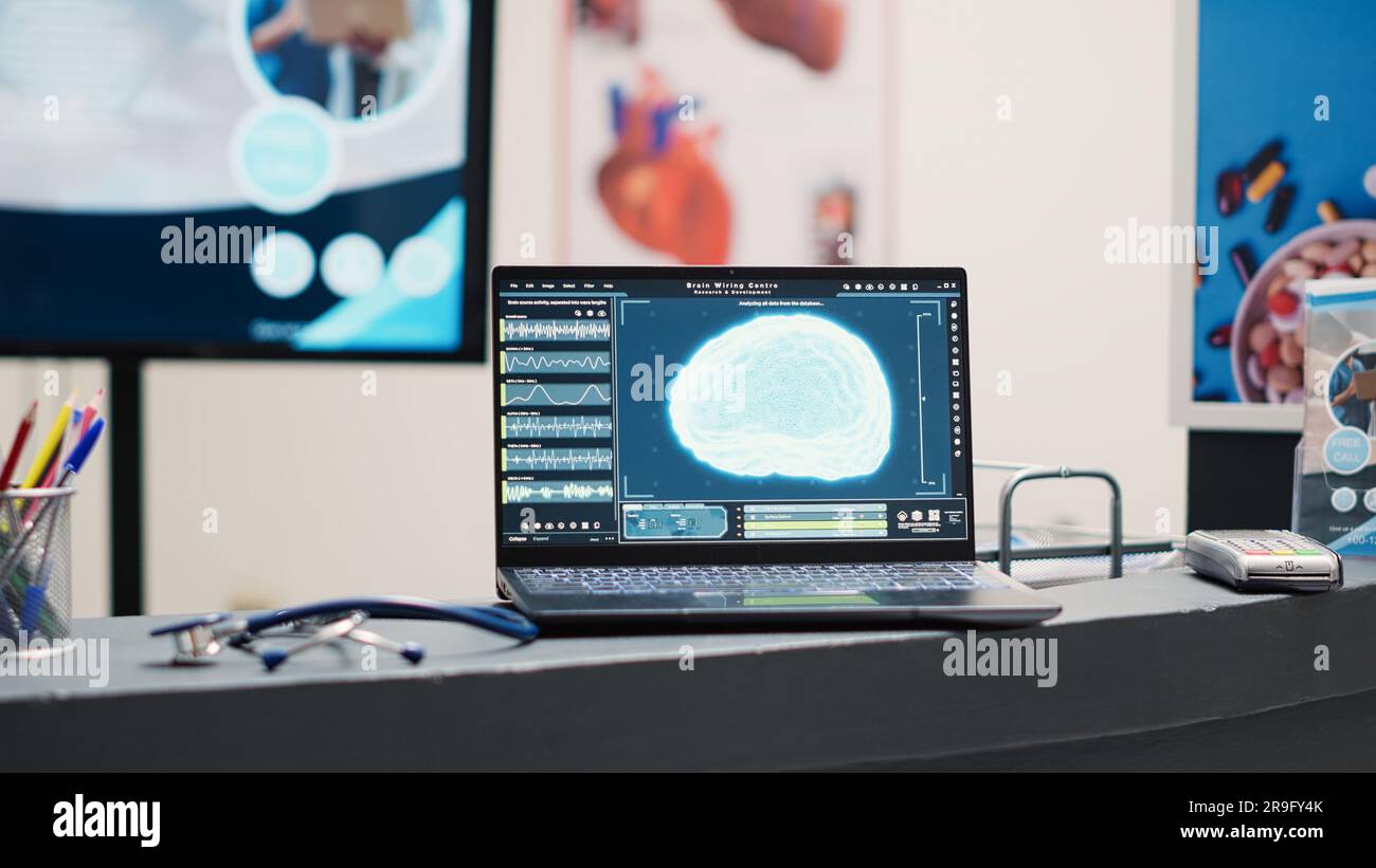 Laptop showing neural system on desk in medical diagnostic center ...