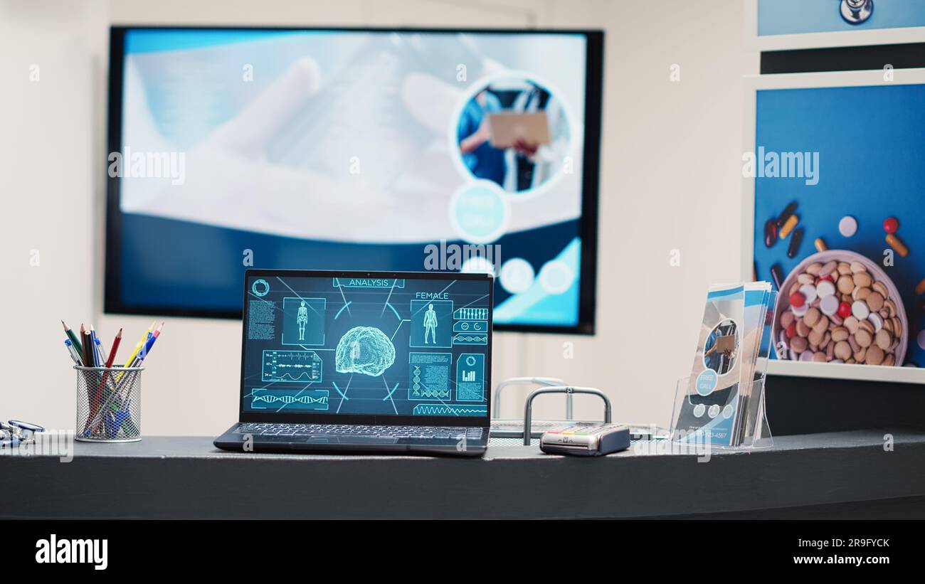 Registration desk with brain on laptop, showing neurology x ray scan ...