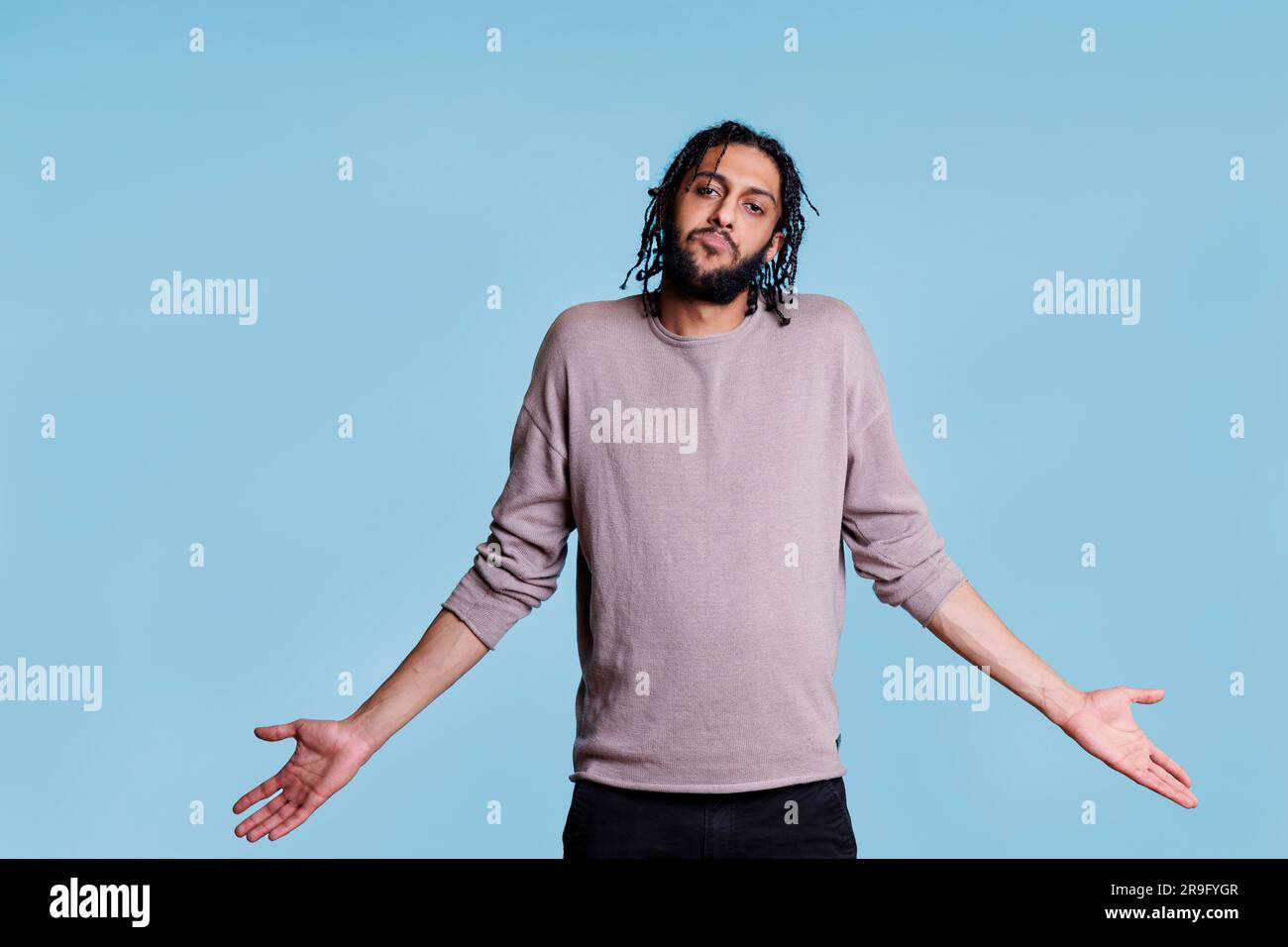 Puzzled arab man with hands spread in questioning gesture looking at ...