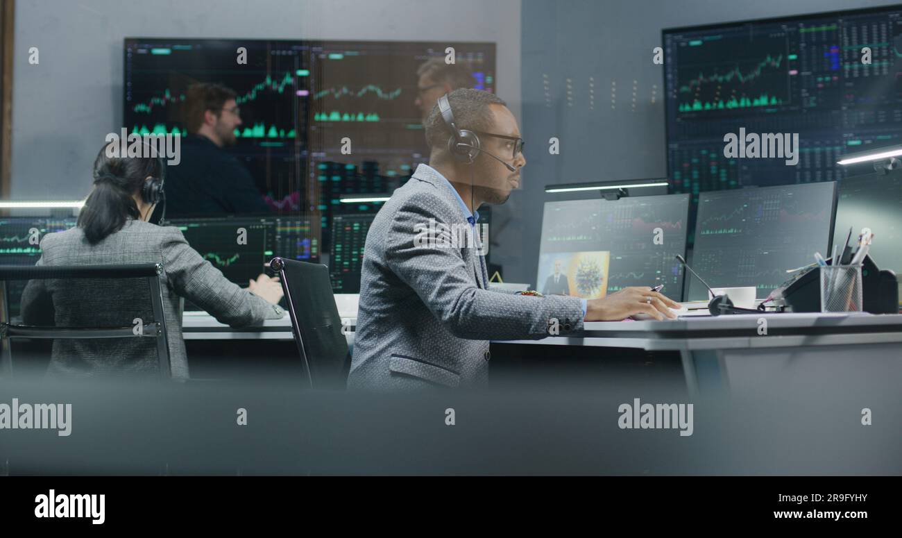 African American financial analyst monitors real-time stocks on ...