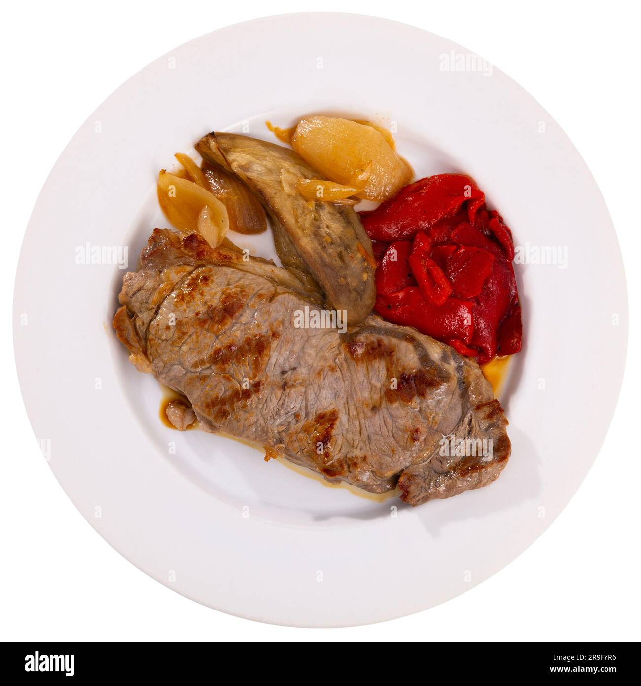 On round white plate lies juicy fried slice of beef tenderloin ...