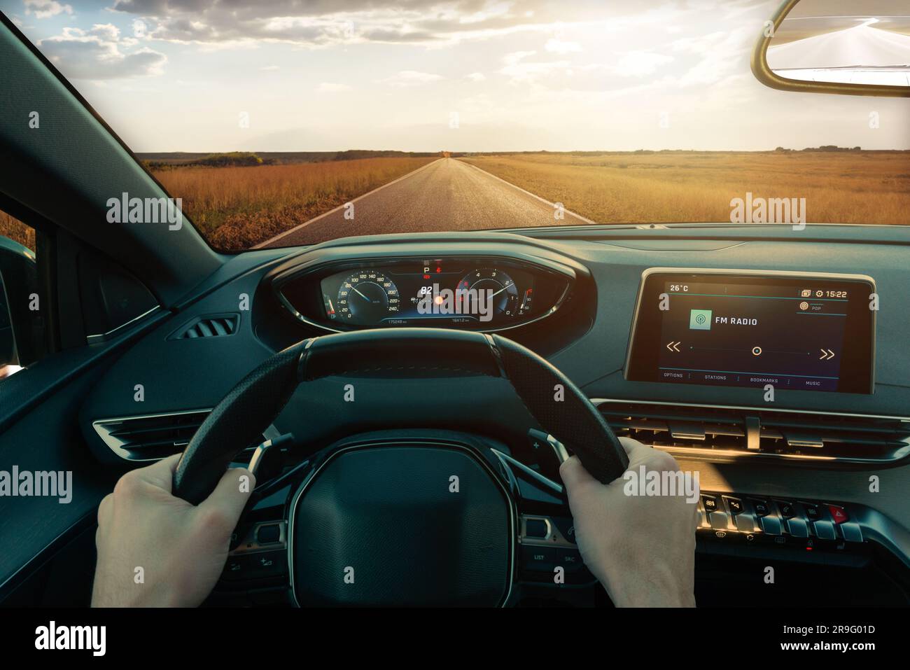 Driving car through a perfect road. Fields illuminated by sunrays ...