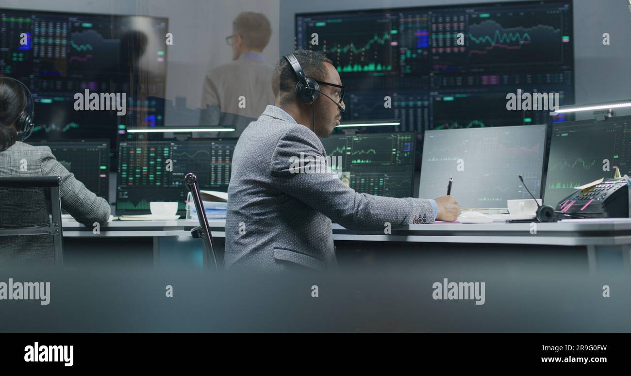 African American financial analyst monitors real-time stocks on ...