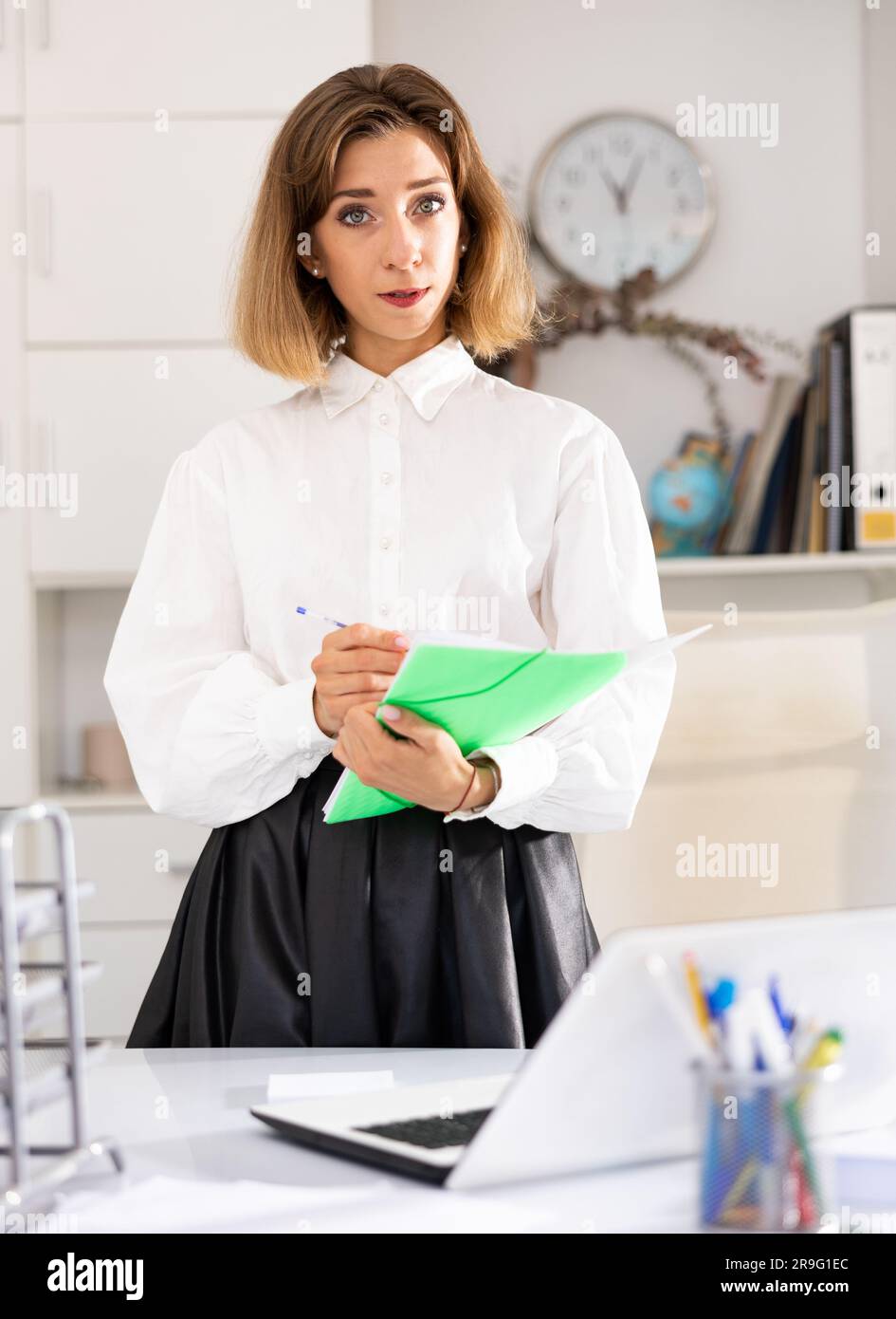 Positive girl secretary with folder for documents in office Stock Photo ...
