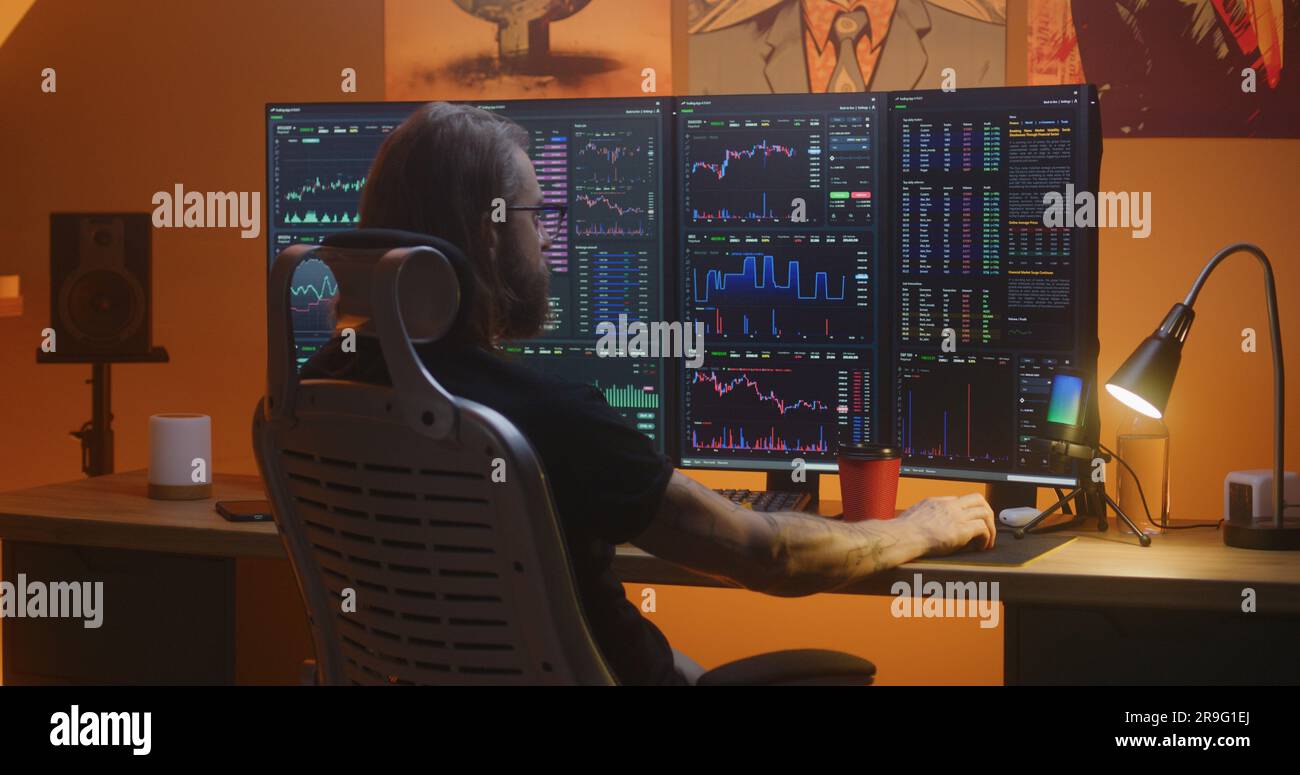 Male stock trader analyzes real-time stocks, exchange market charts on multi-monitor computer ...