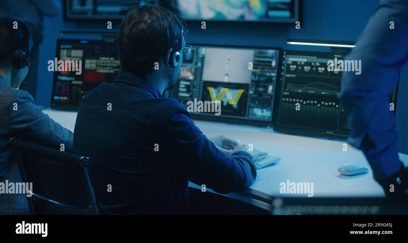 Flight control operators in headsets monitor space mission on computer ...