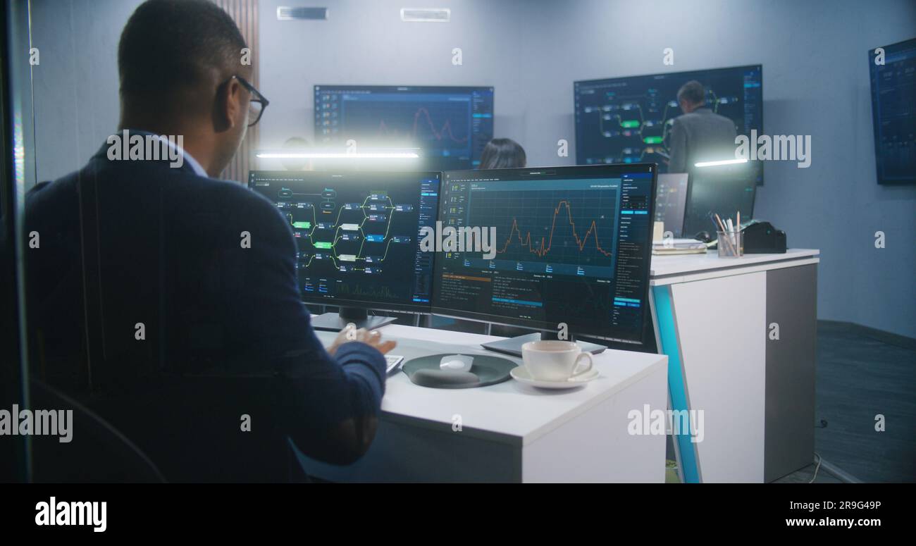 Male African American engineer types keyboard and analyzes displayed ...