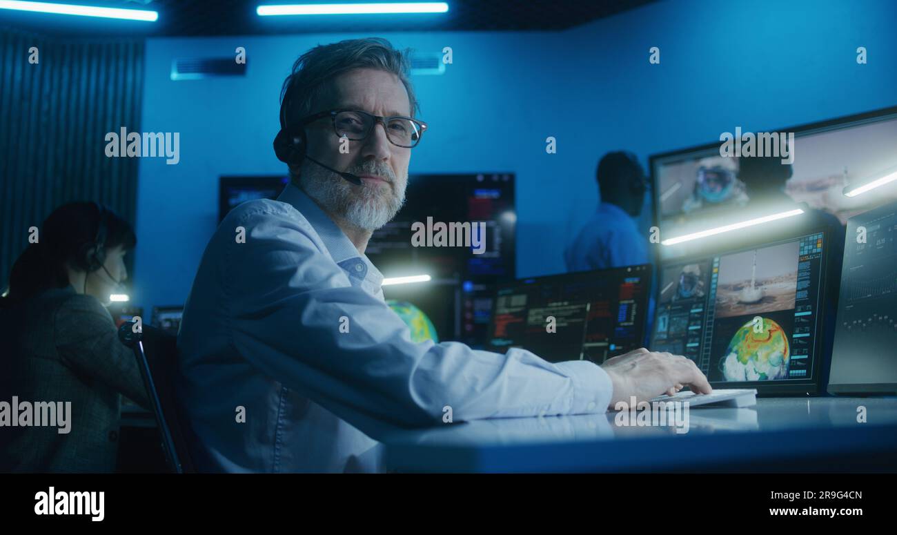 Flight control employee in headset sits in front of computers, monitors ...