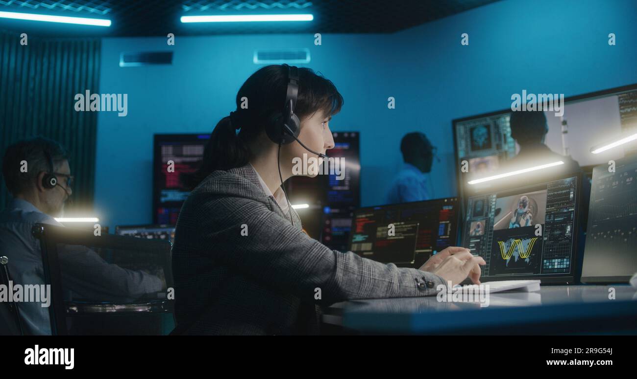 Female flight control worker in headset sits in front of computer ...
