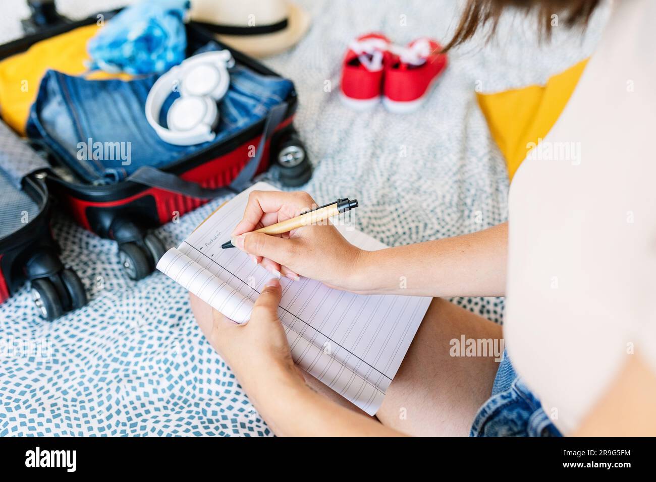 Close up view of young woman hands preparing travel summer check list ...