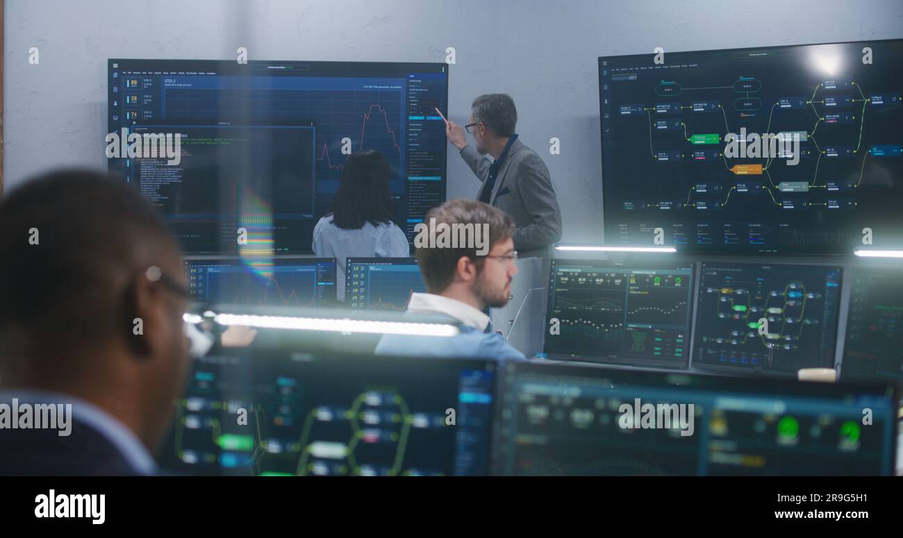 Technical support specialists sit at computers with displayed blockchain network map and server ...