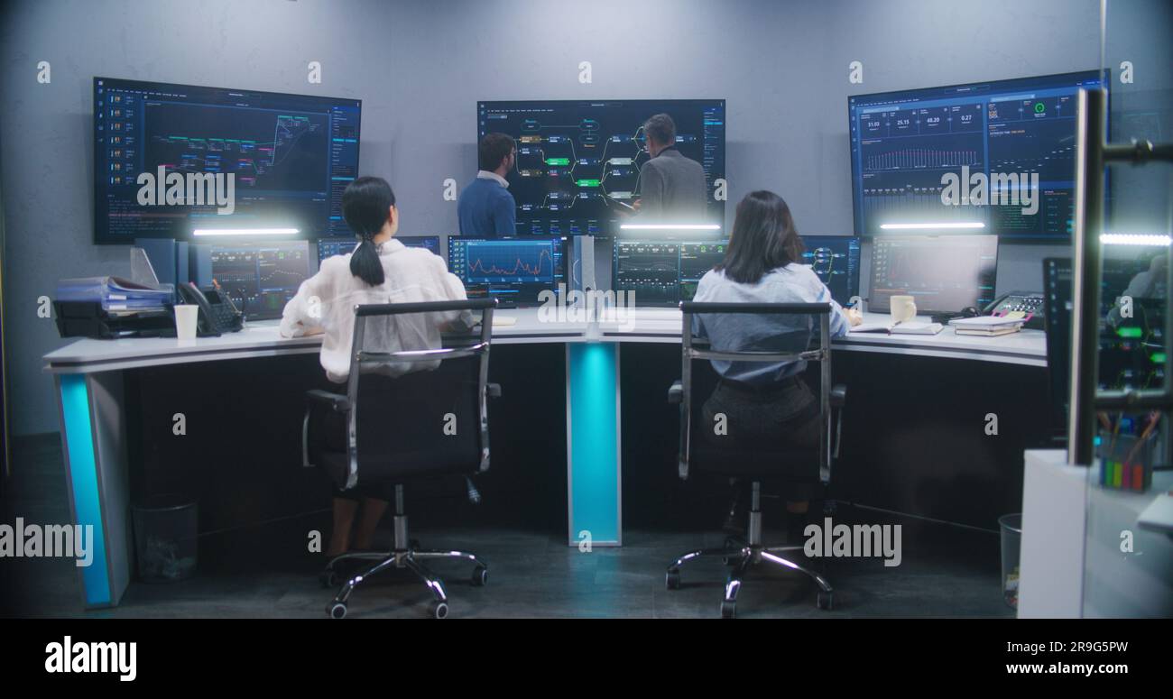 Female software engineer sits at computer with displayed blockchain network and surveillance ...