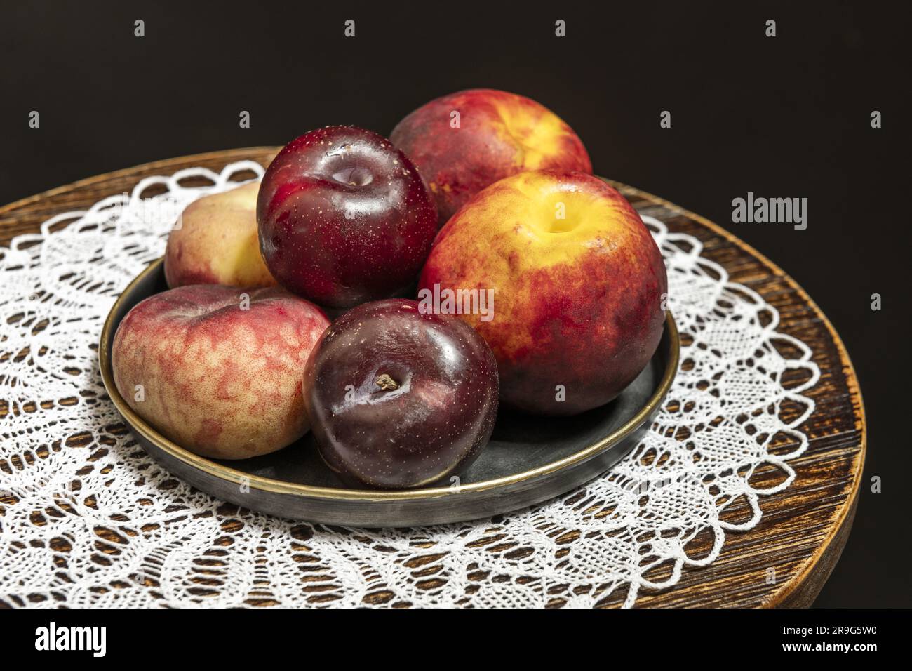 Simple still life with ripe summer fruit on a crocheted doily on a ...