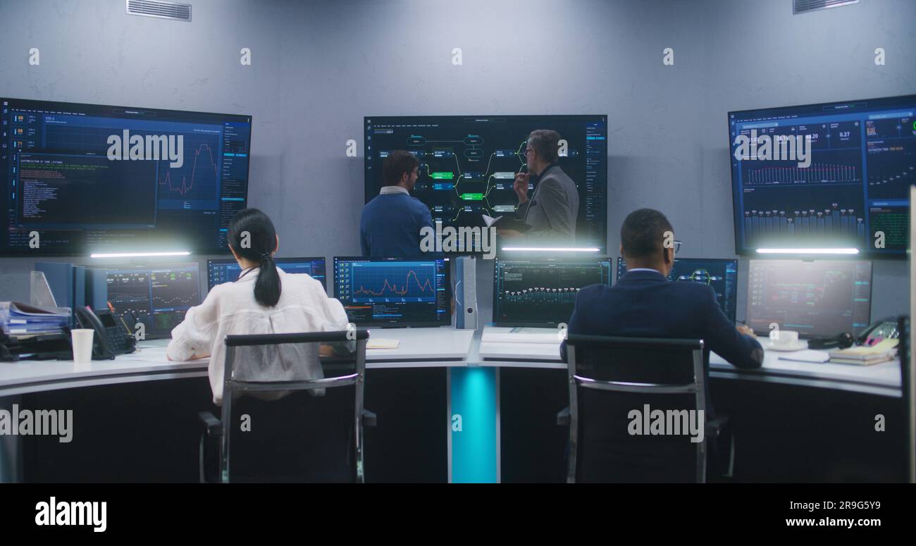 Female software engineer sits at computer with displayed blockchain network and surveillance ...