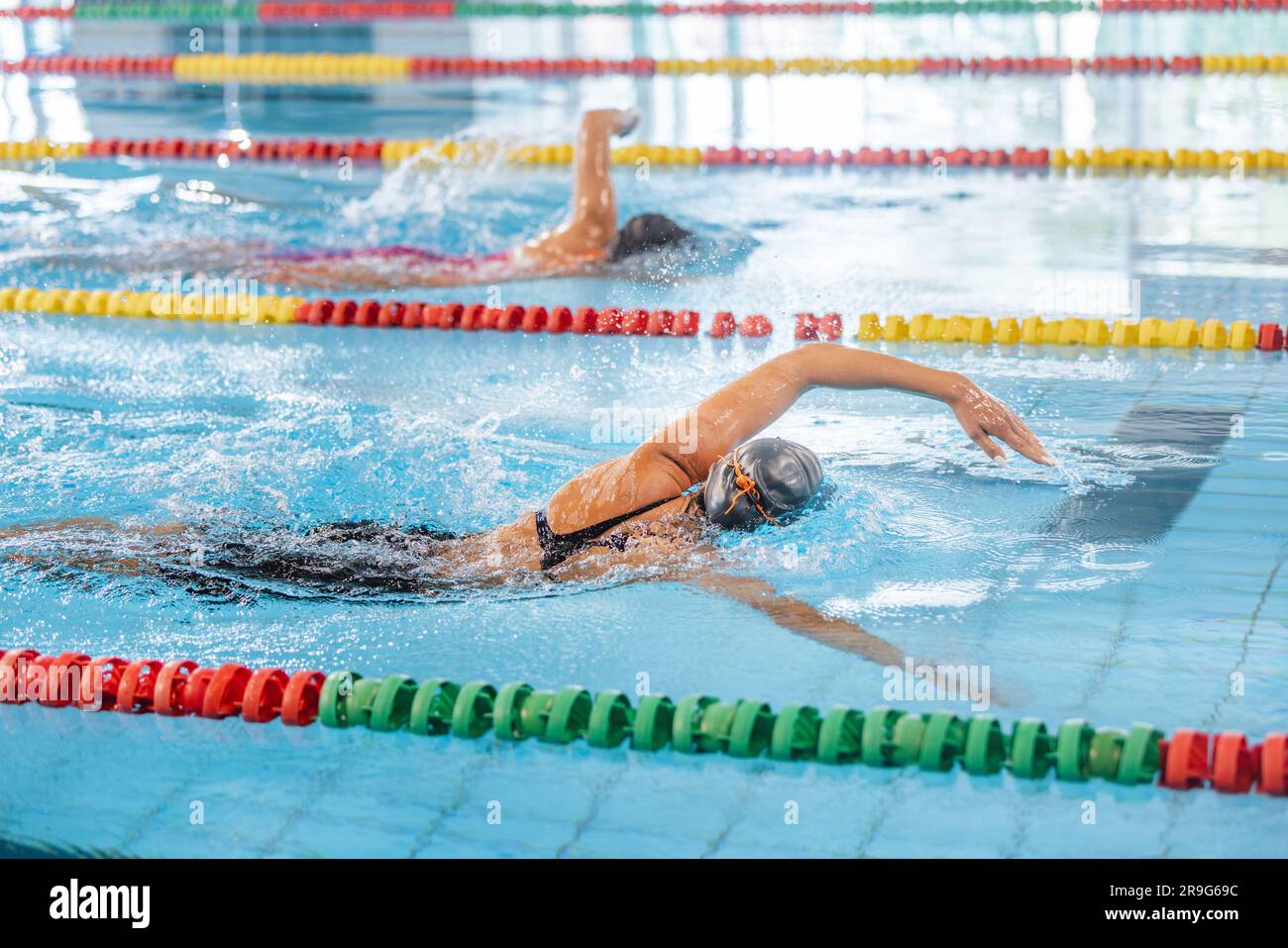 Athletic female swimmer using freestyle technique in pool lane ...