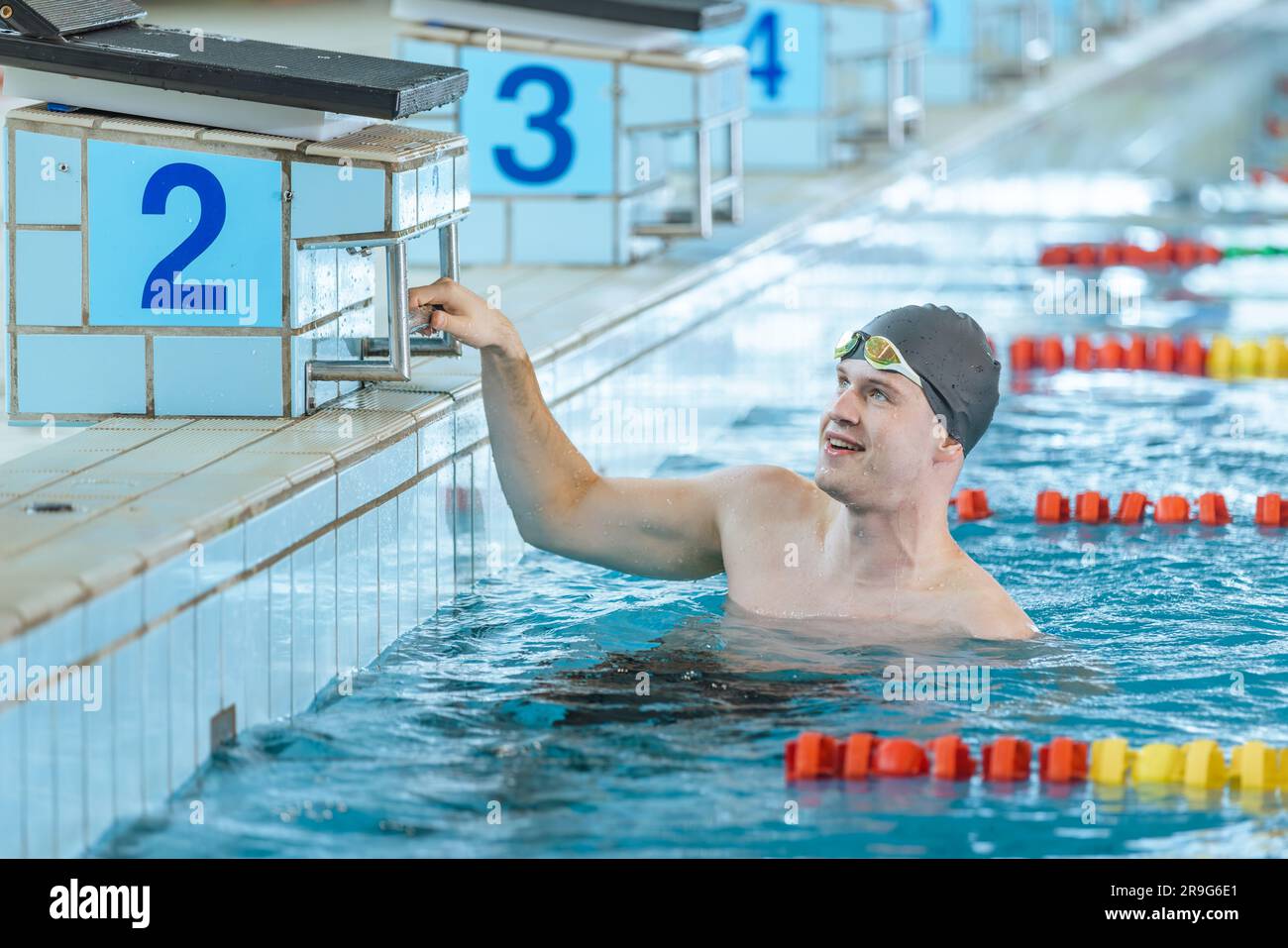 Man swimmer happy at the finish of a race in the pool at competition ...
