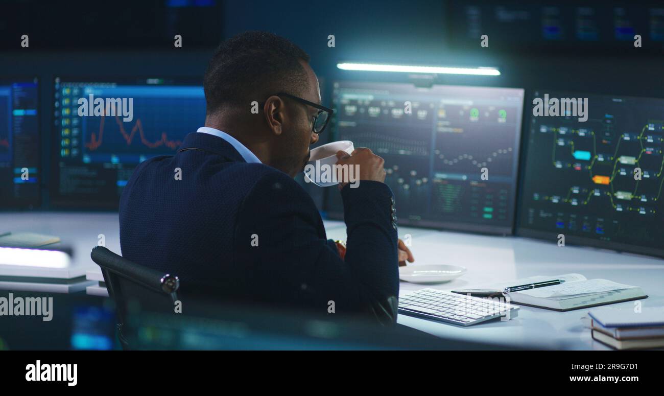 African American IT technical specialist works on computer with data ...
