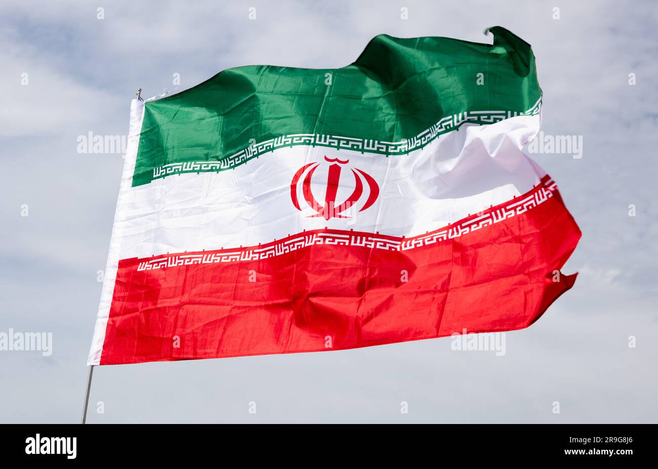Flag of Iran waving on cloudy sky during daytime Stock Photo - Alamy