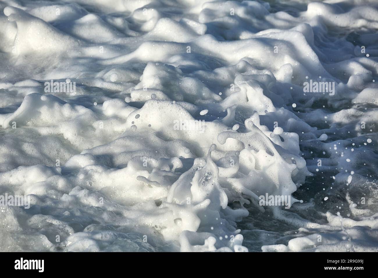Waves with foam splasing in sea water Stock Photo - Alamy