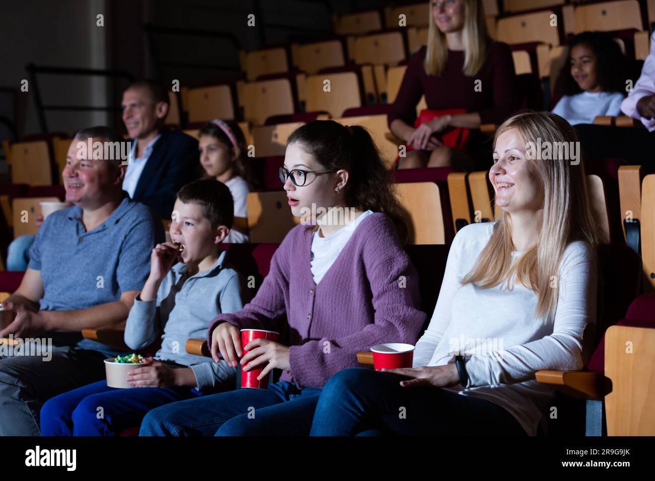 Spectators eating popcorn and watching movie at the cinema Stock Photo ...