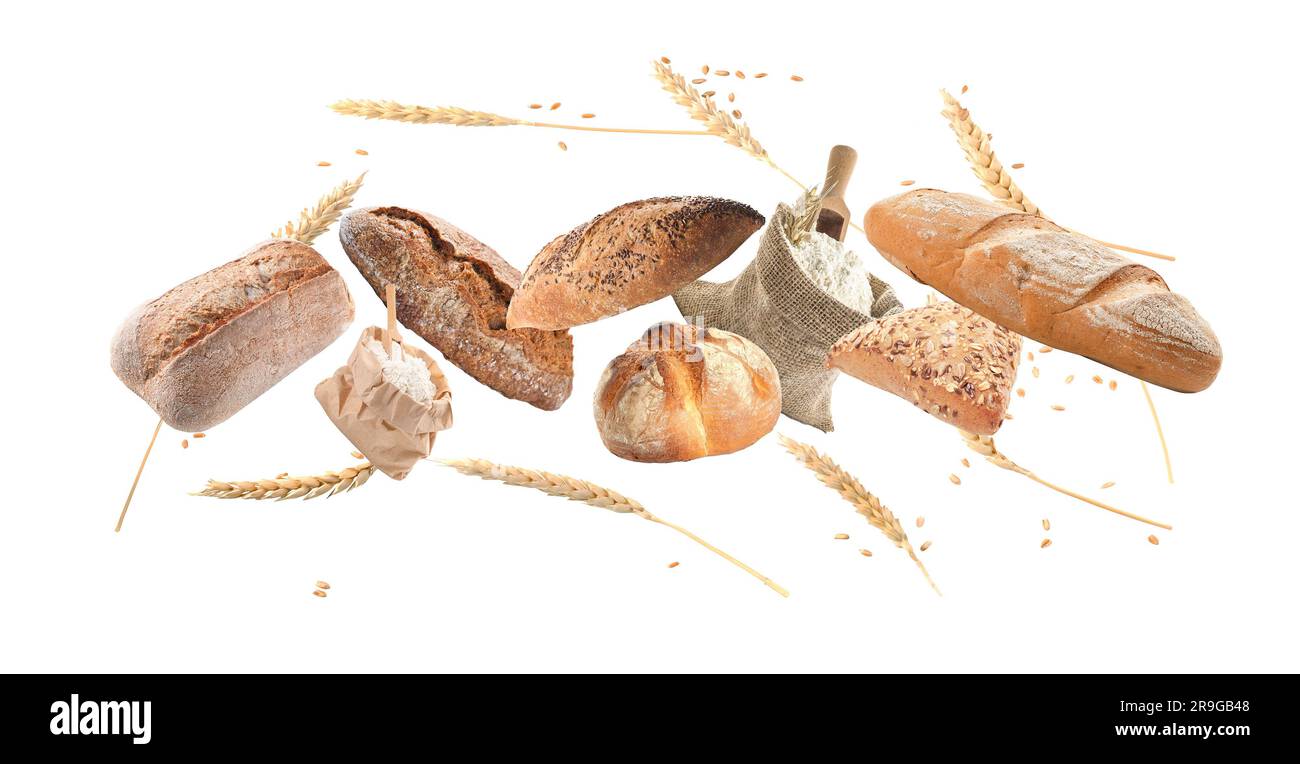 Flying fresh bread with spikelets, seeds and flour on white background ...