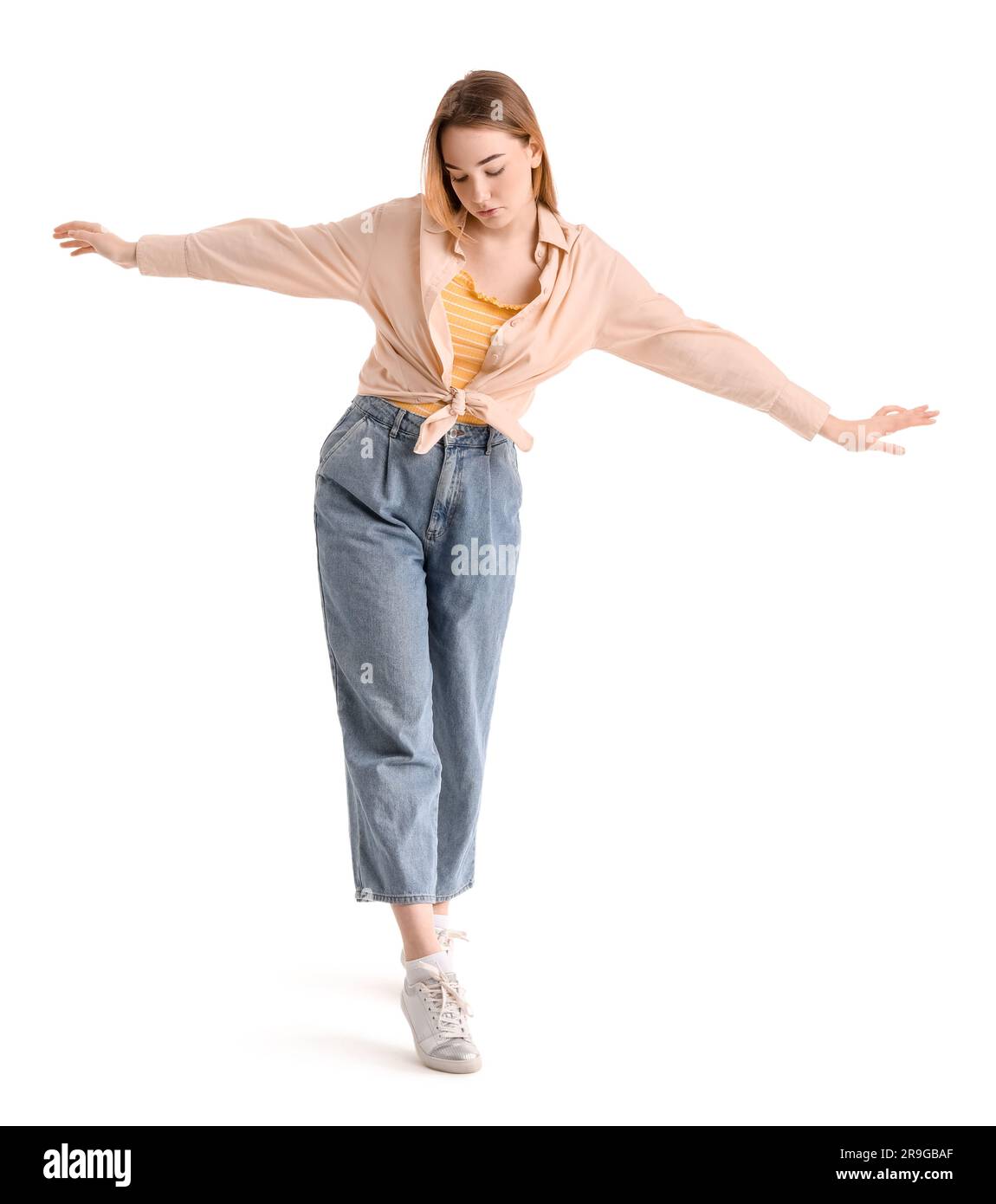 Young woman balancing on white background Stock Photo - Alamy