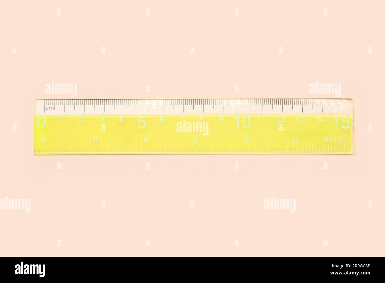 Yellow plastic ruler on beige background Stock Photo - Alamy