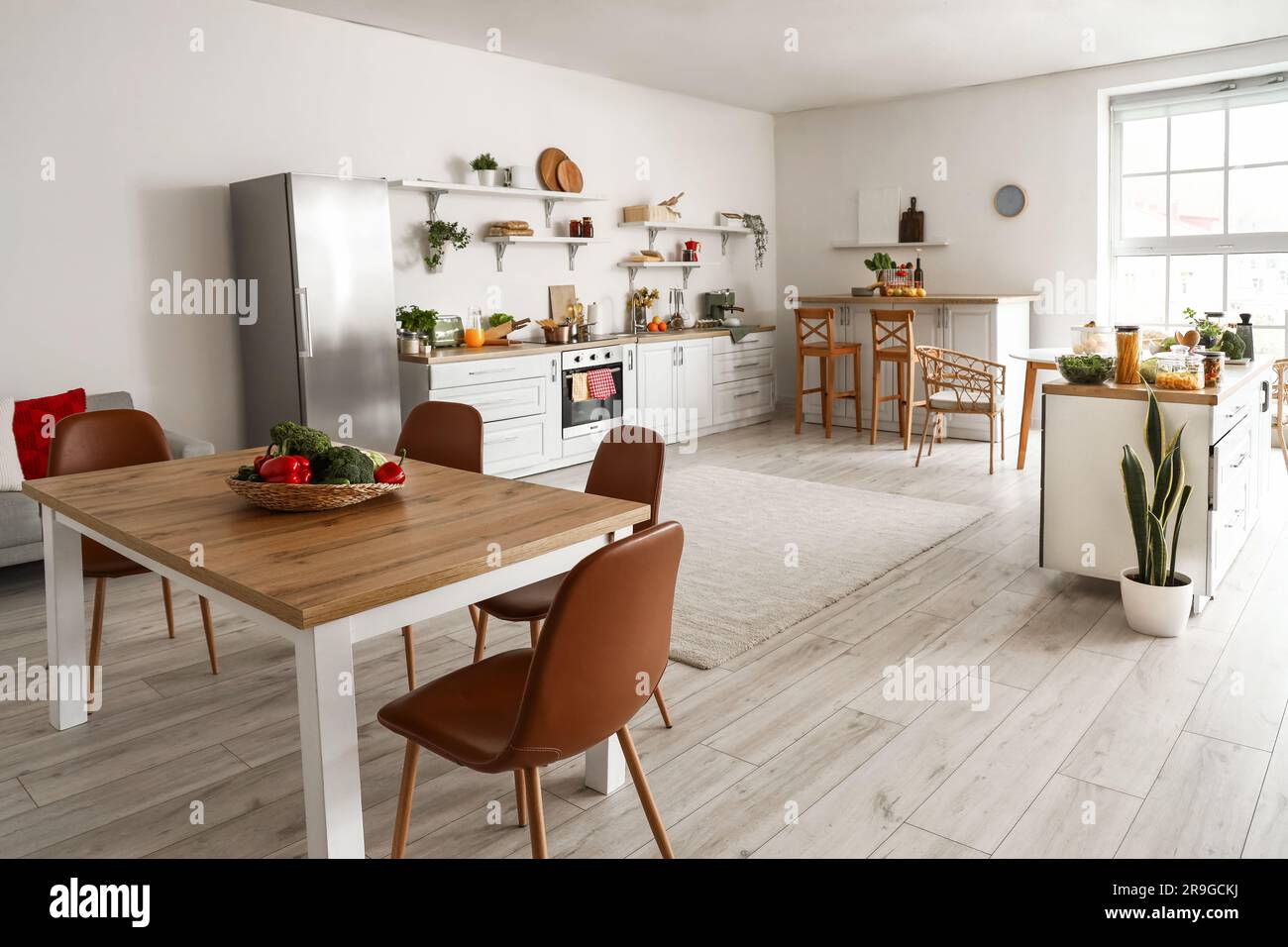 Interior of light kitchen with counters, shelves and dining table Stock ...