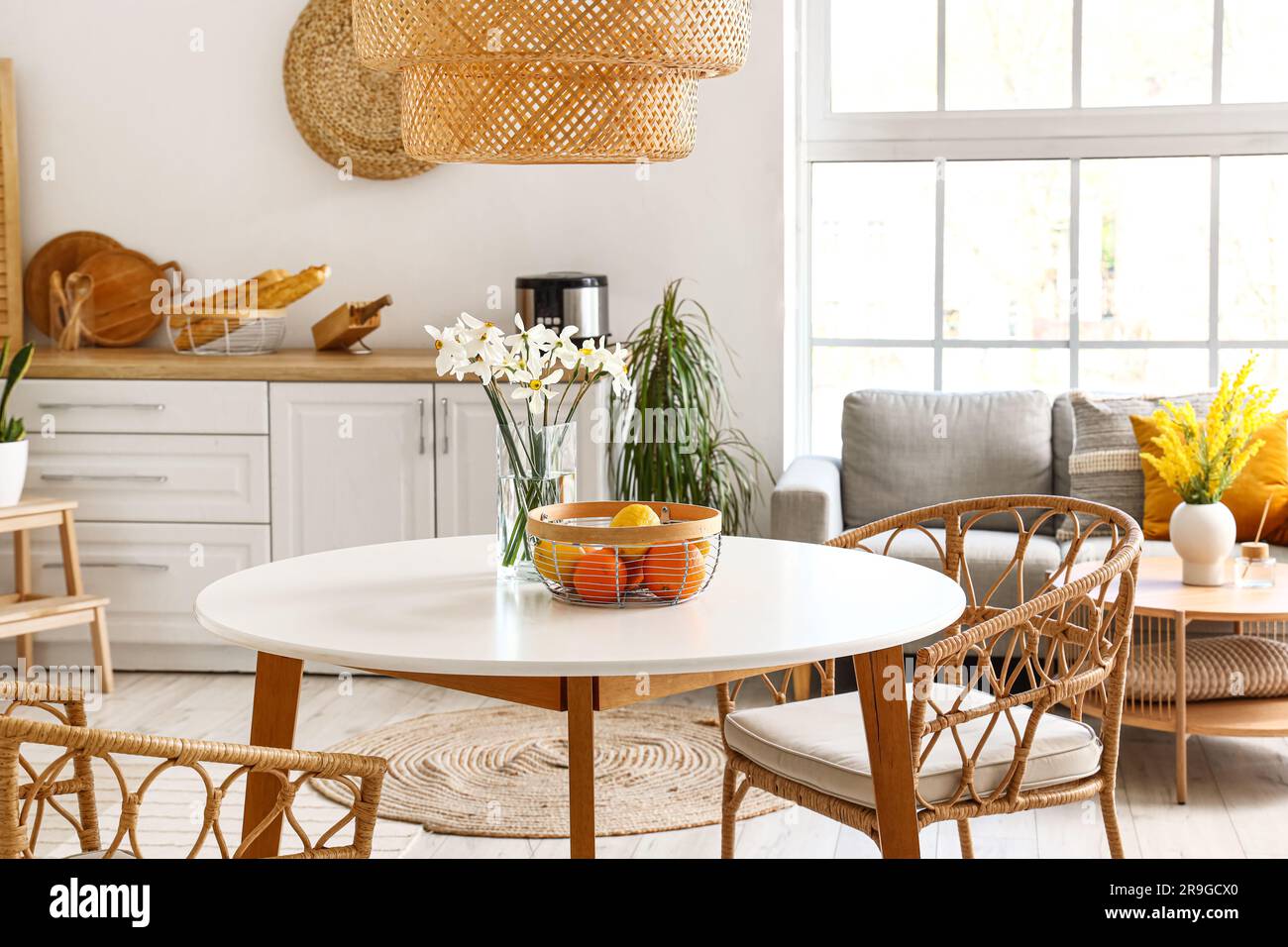 Interior of light kitchen with stylish counters, table, chairs and sofa ...