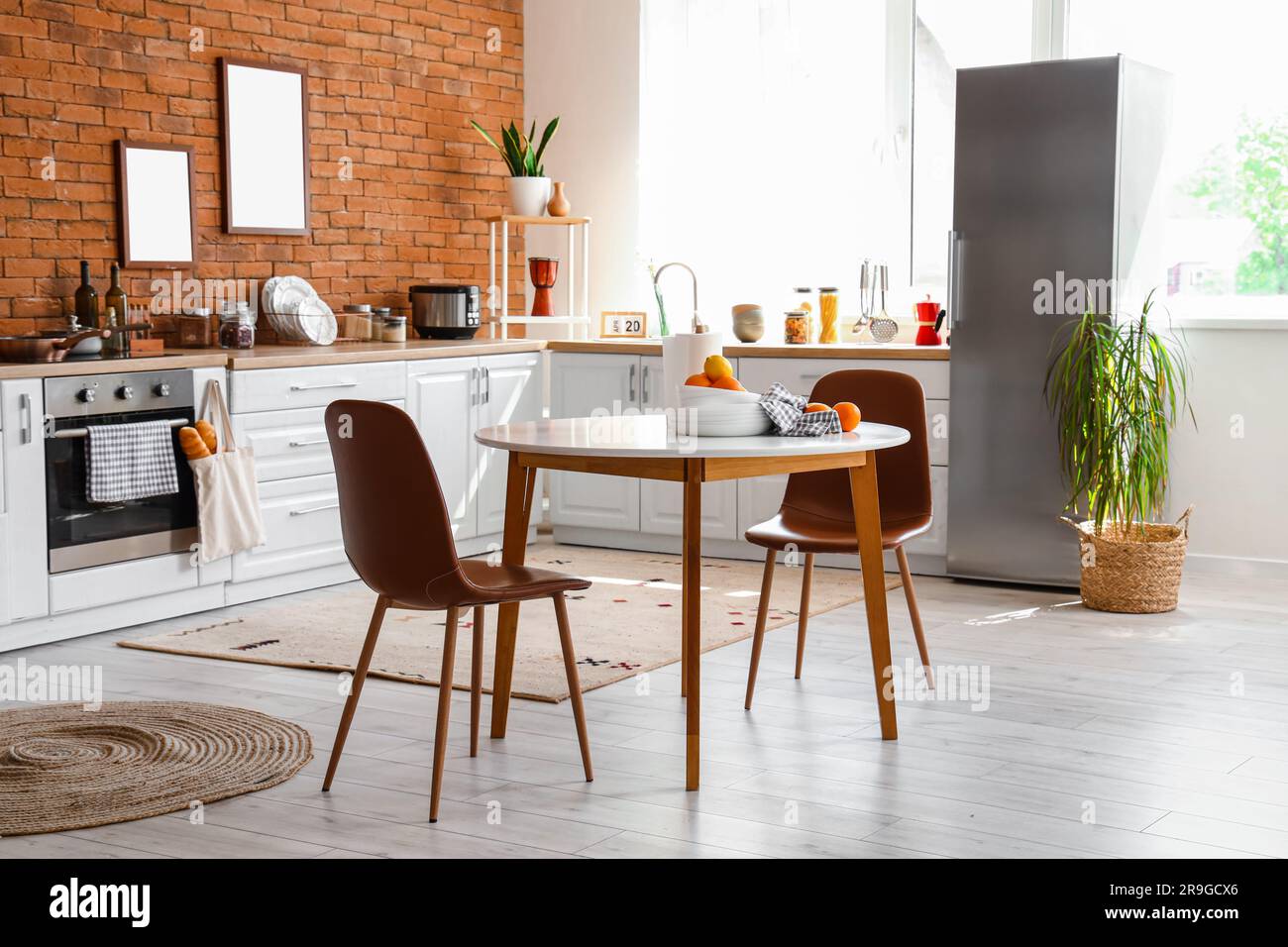 Interior of kitchen with stylish fridge, counters, table and chairs ...