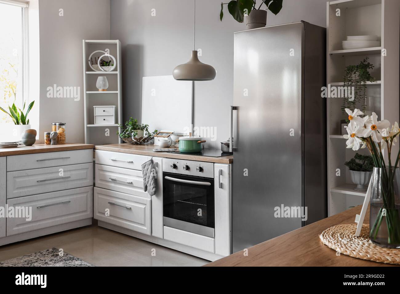 Interior of light kitchen with stylish fridge, counters and shelving ...