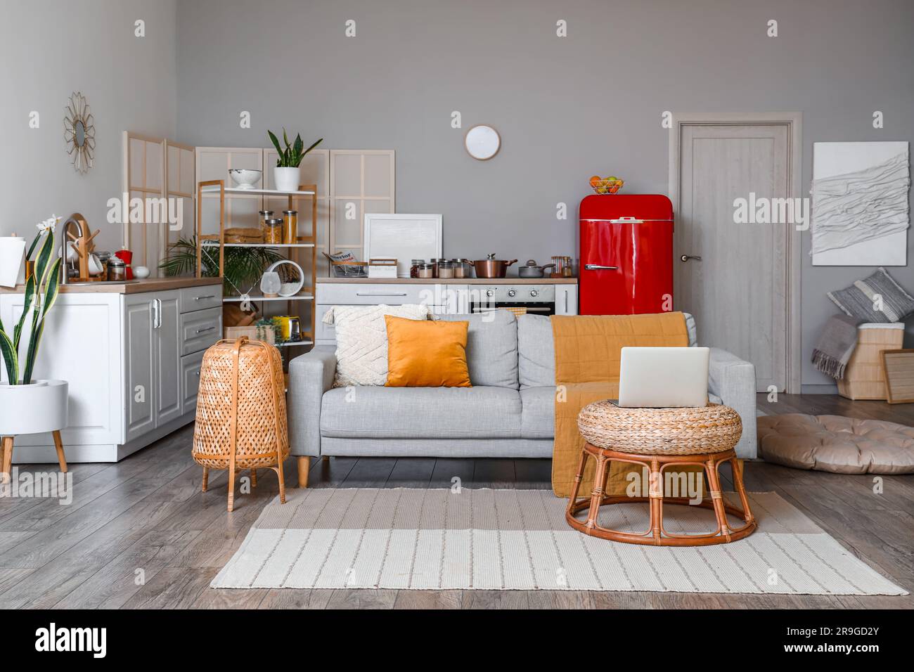 Interior of kitchen with red fridge, counters, sofa and laptop computer ...