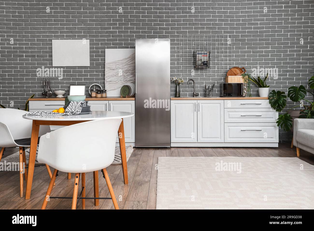 Interior of kitchen with stylish fridge, counters, table and chairs ...