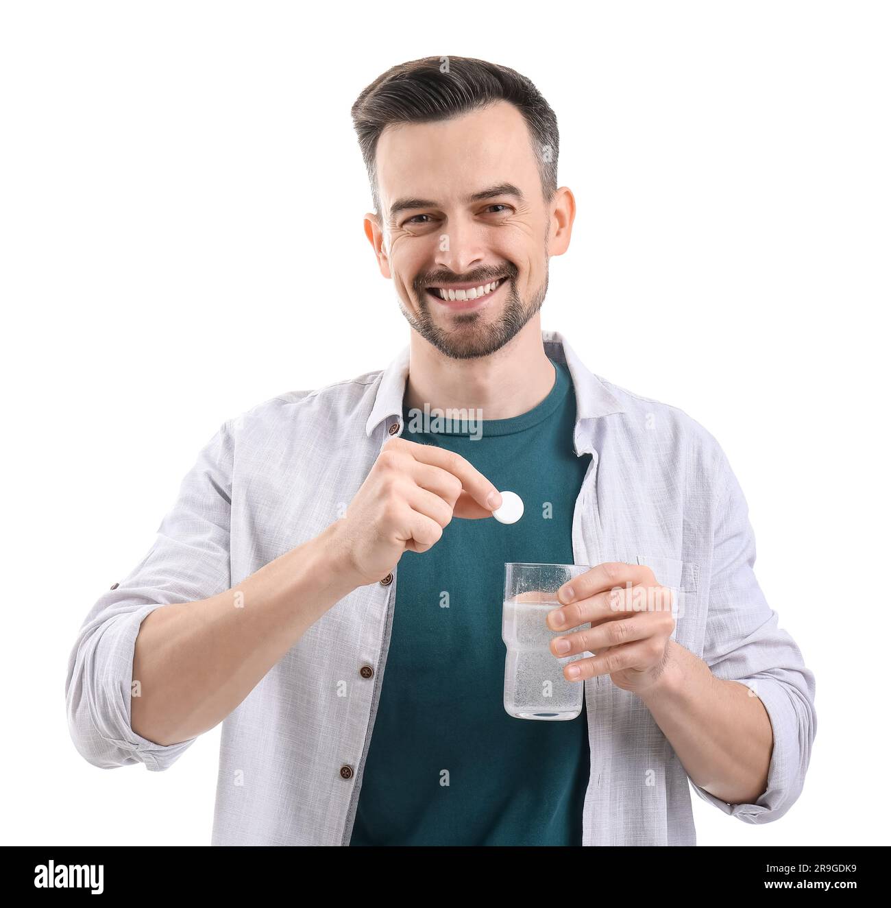 Young man with soluble tablet and glass of water on white background ...