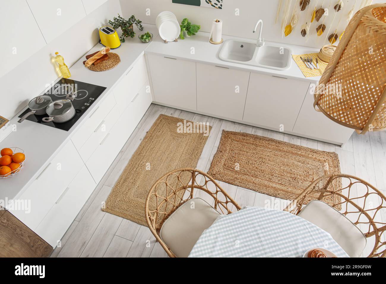 Stylish wicker rugs in interior of modern kitchen Stock Photo - Alamy